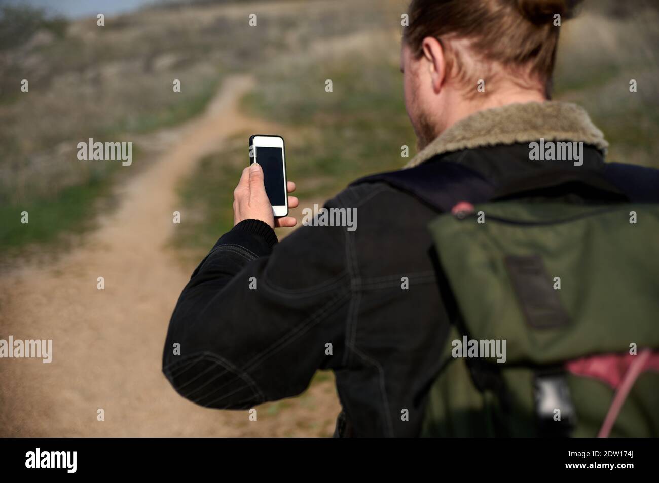 View from the back of a hiking adventurer man using compass on ...