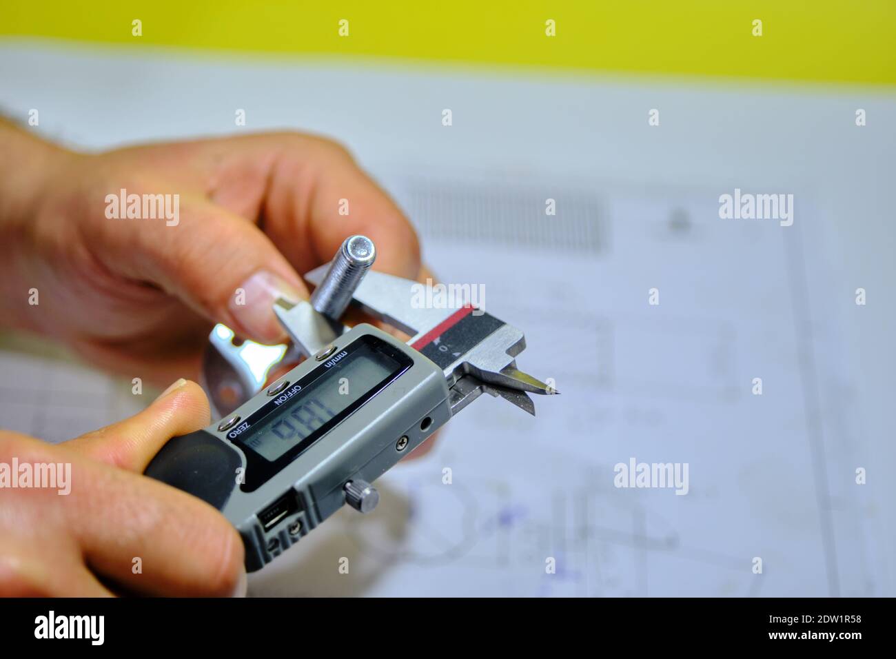 A man hand measuring the M8 bolt bonding fastener by means of calliper ...