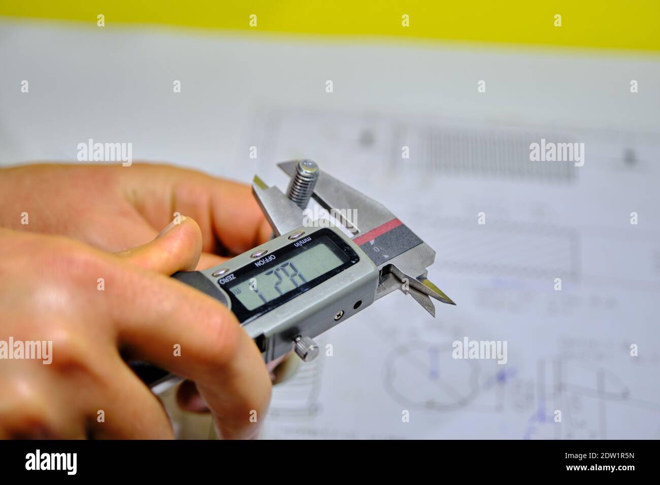 A man hand measuring the M8 bolt bonding fastener by means of calliper ...