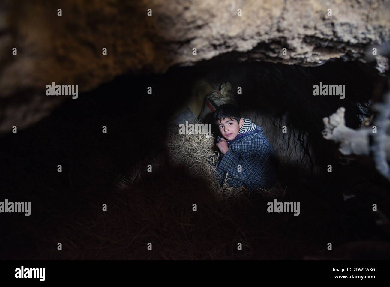 A Kashmiri boy looks on as he sits inside the cave in Tral Pulwama.The ...
