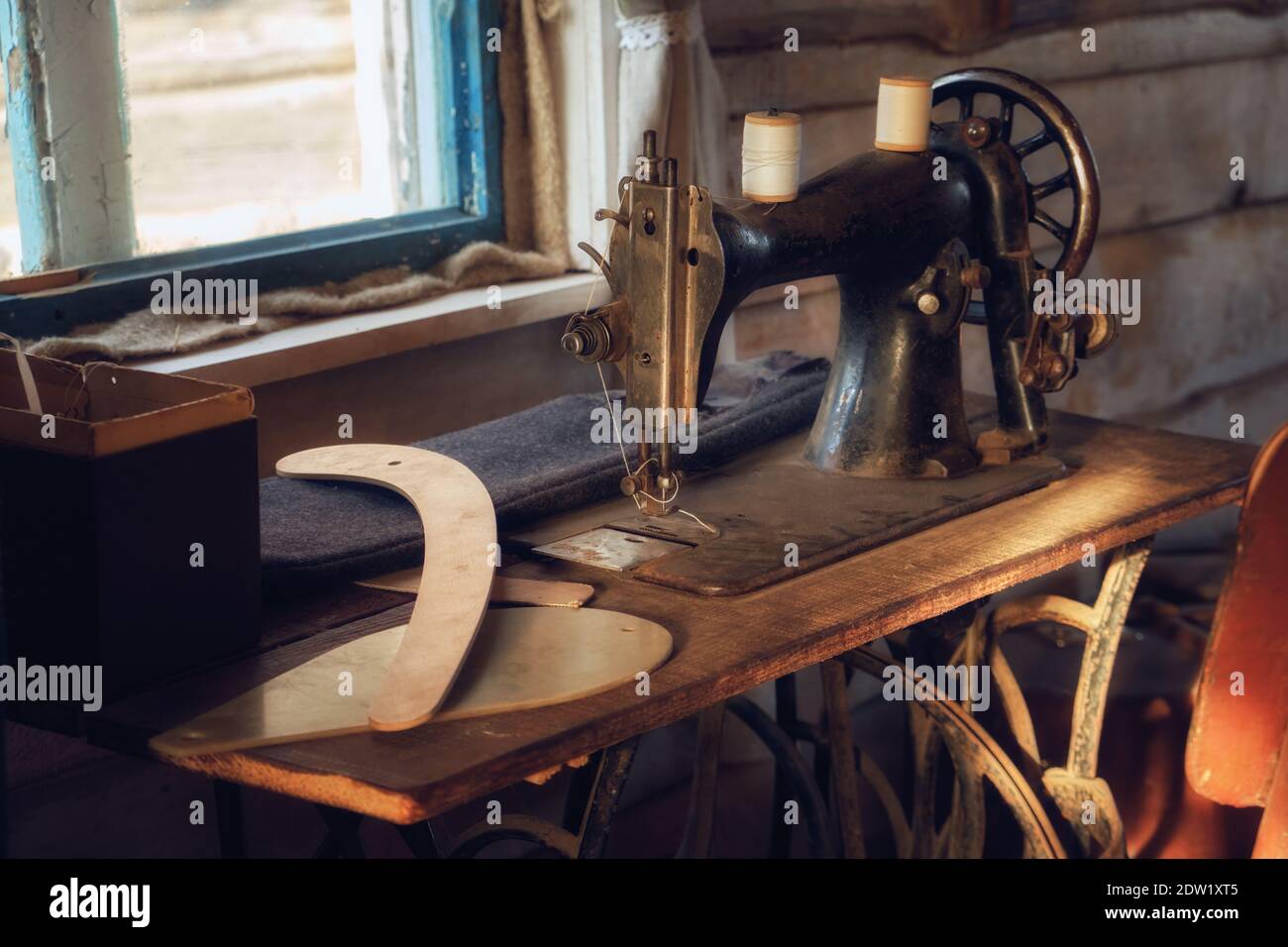 Old antique sewing machine, wooden sewing layouts and lying fabrics in ...
