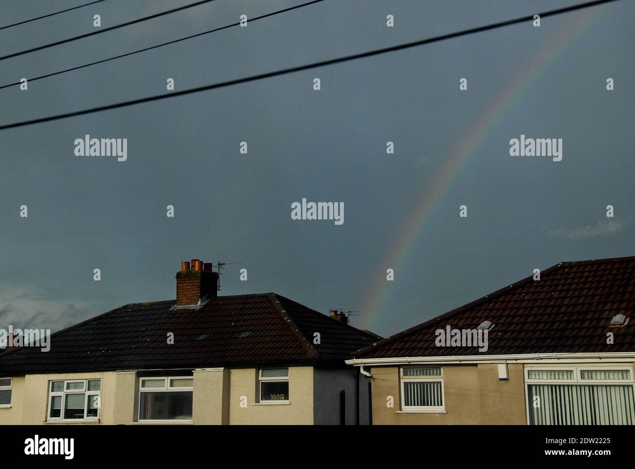 Rainbow over houses Stock Photo - Alamy