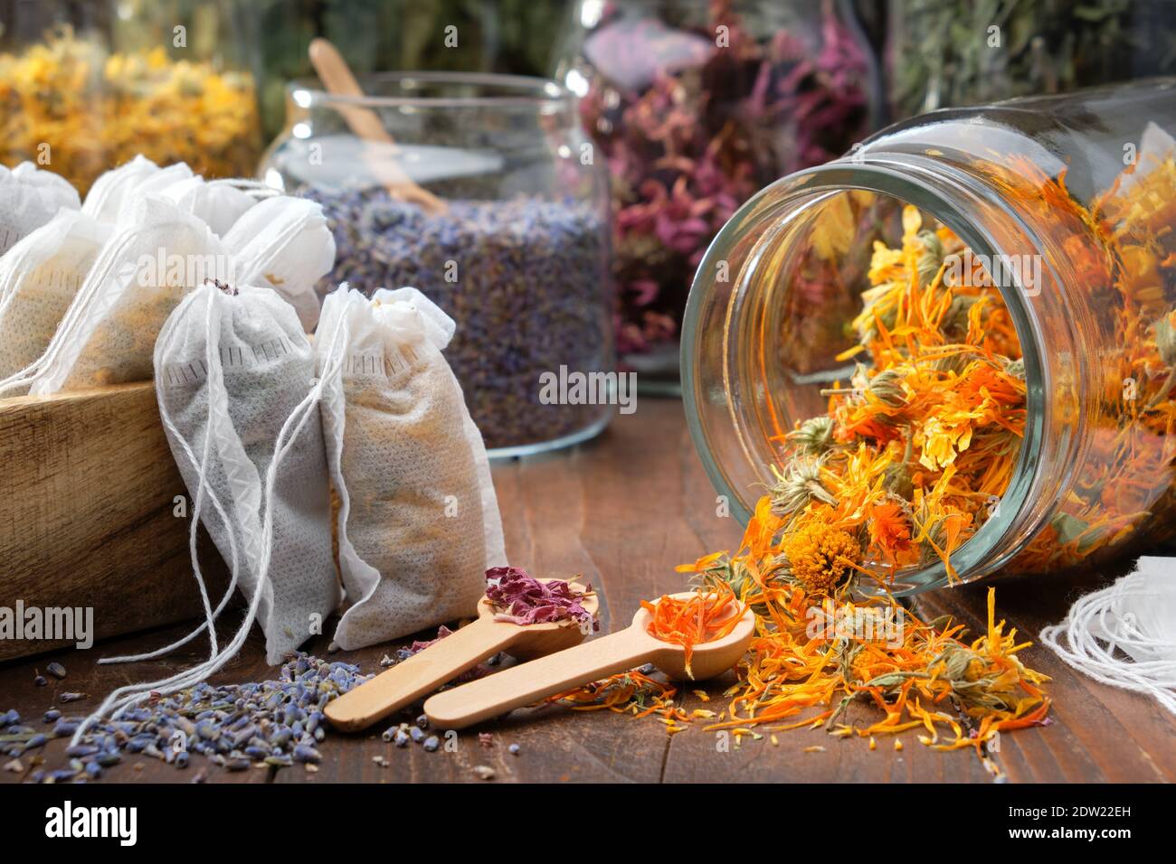 Filter tea bags filled with medicinal herbs. Glass jar of dry calendula ...