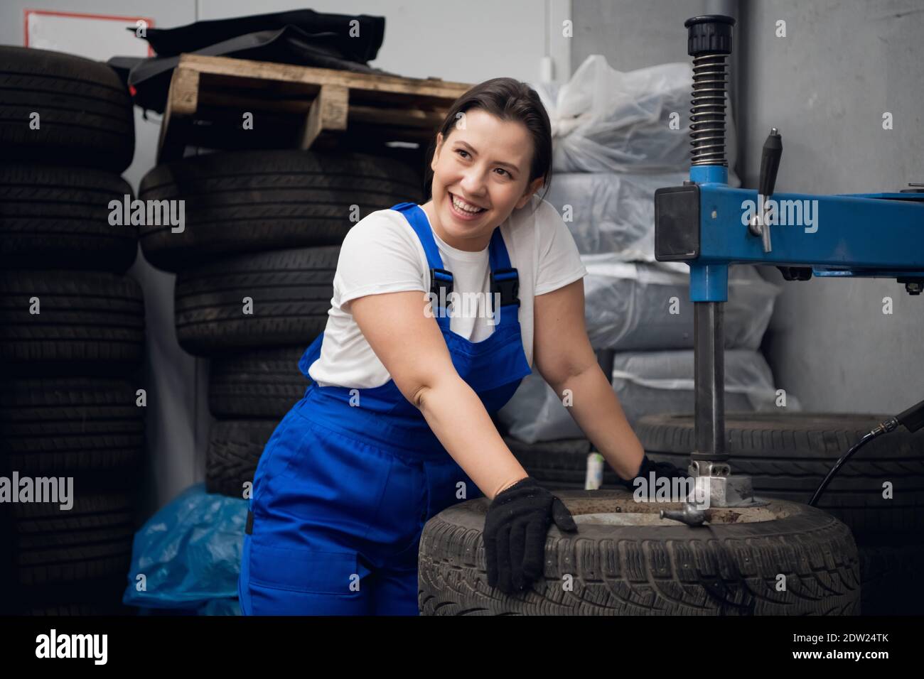 Female mechanic posing next to wheels and a machine tool Stock Photo ...