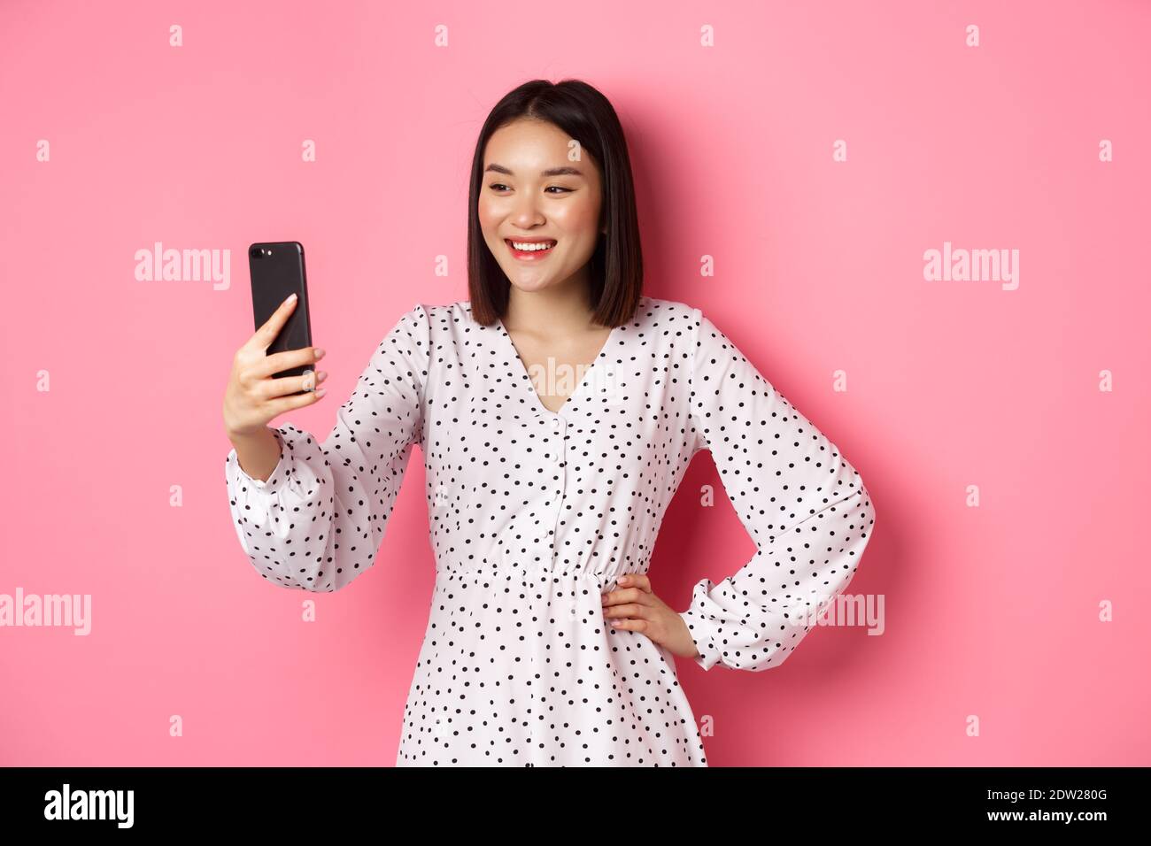 Beautiful asian girl using photo filters app and taking selfie on ...