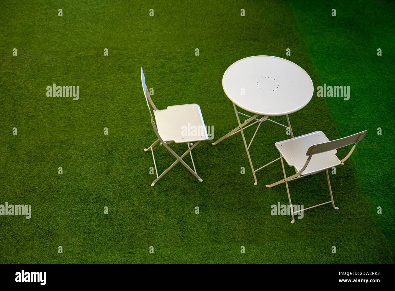 Round table and two folding chairs Stock Photo - Alamy