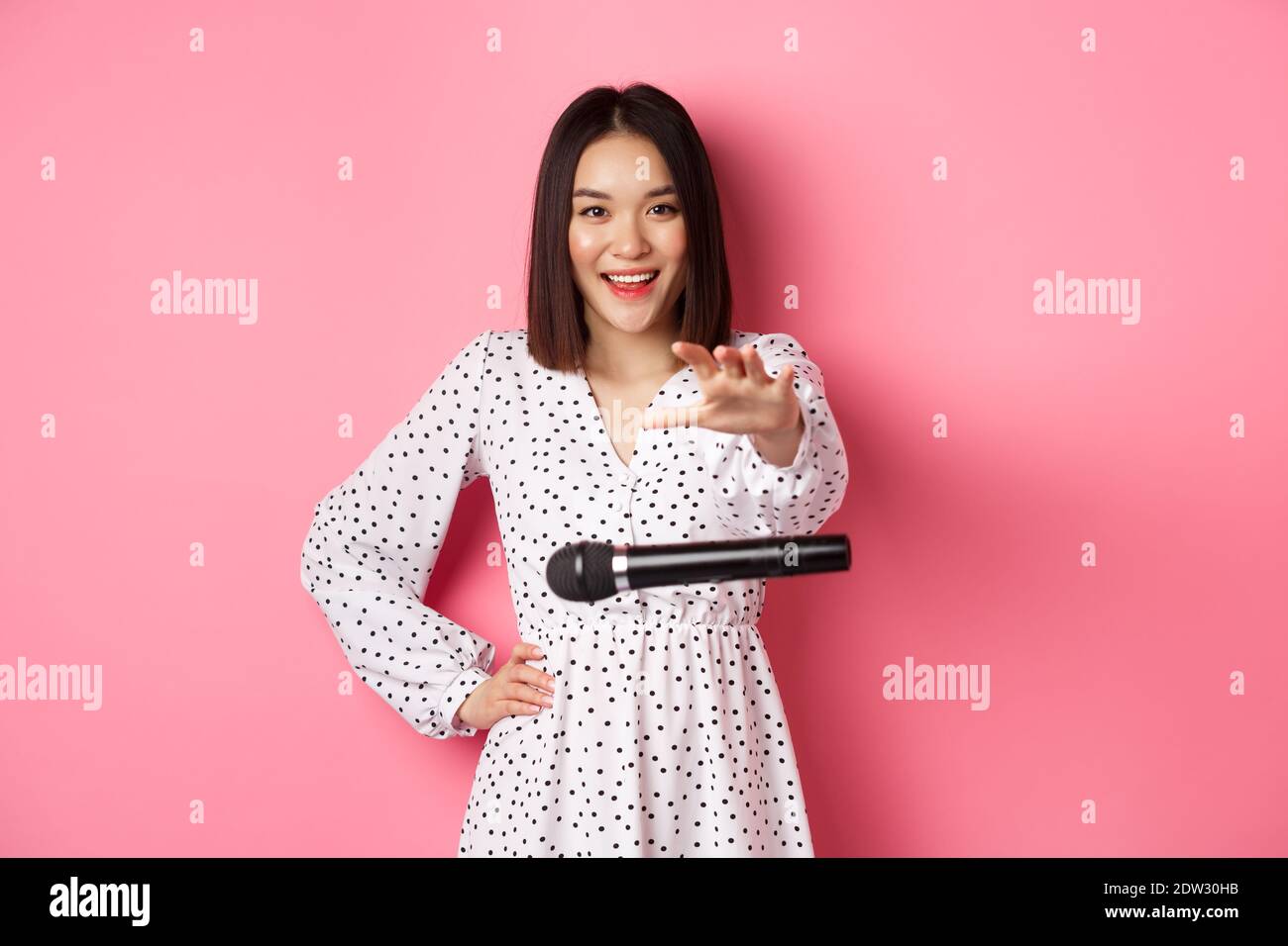 Happy asian woman drop the microphone, smiling and looking confident at ...