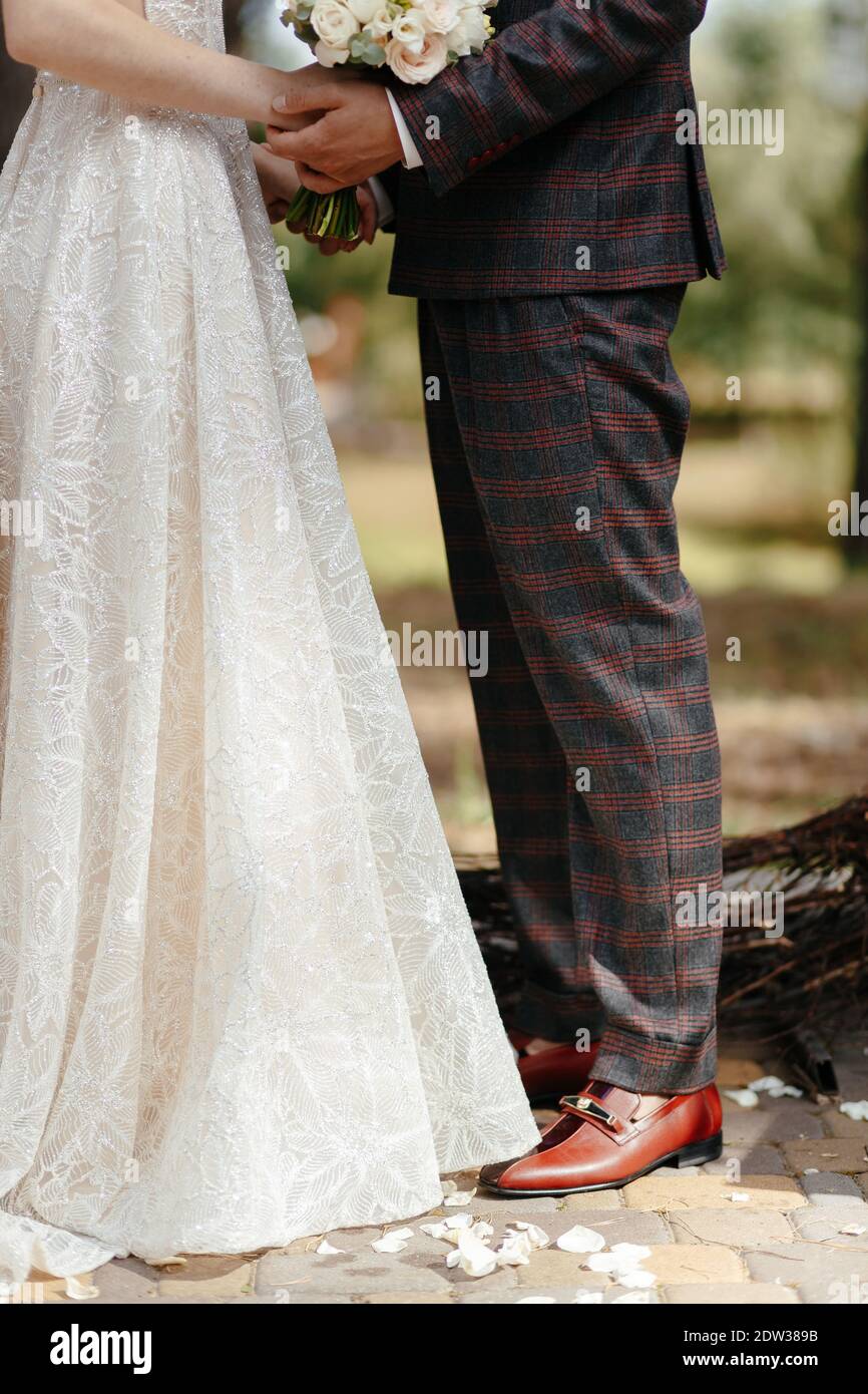 Faceless groom and bride standing opposite each other and holdings each ...
