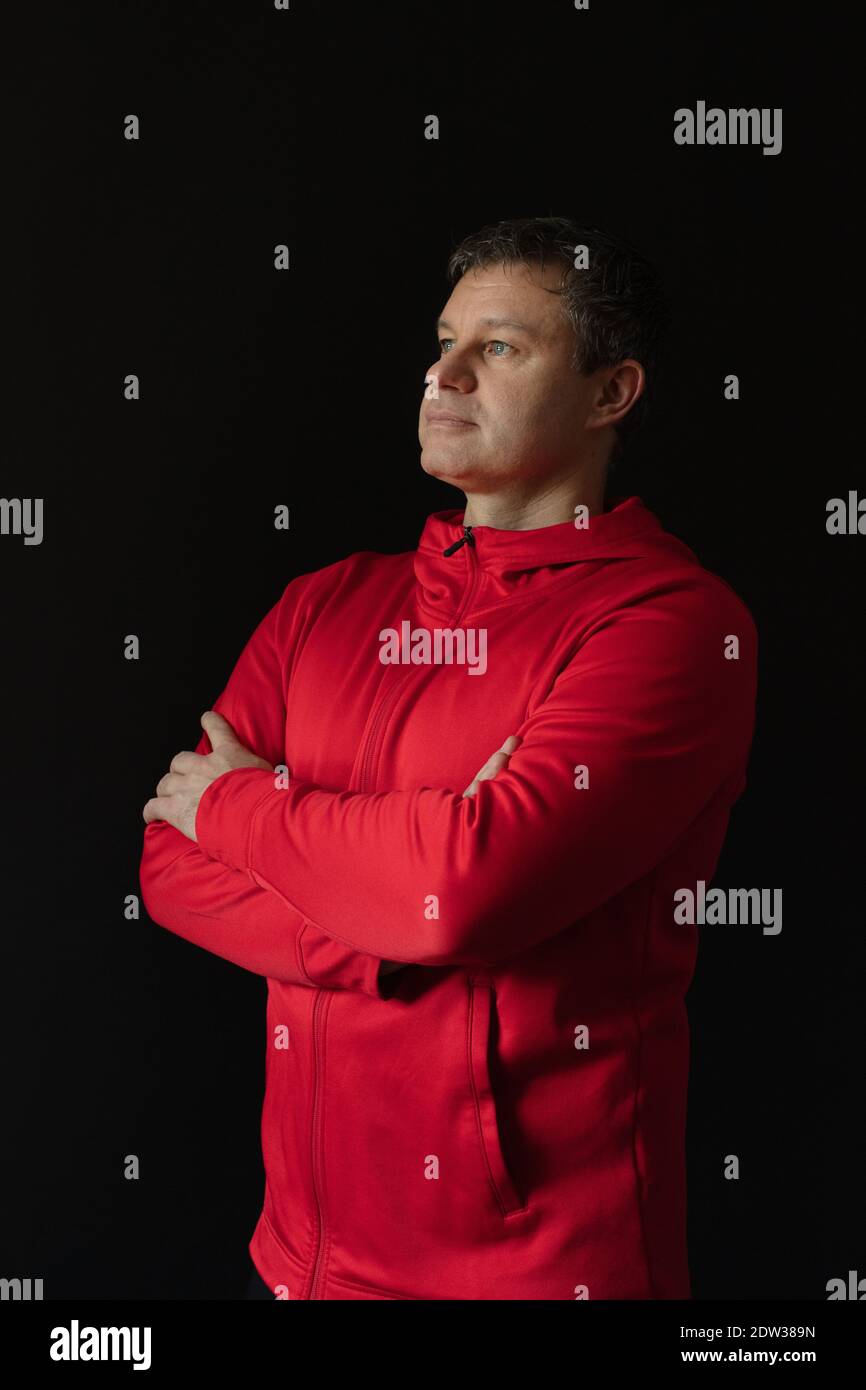 Portrait of a thoughtful male athlete age 35 to 45 in red sports dress ...