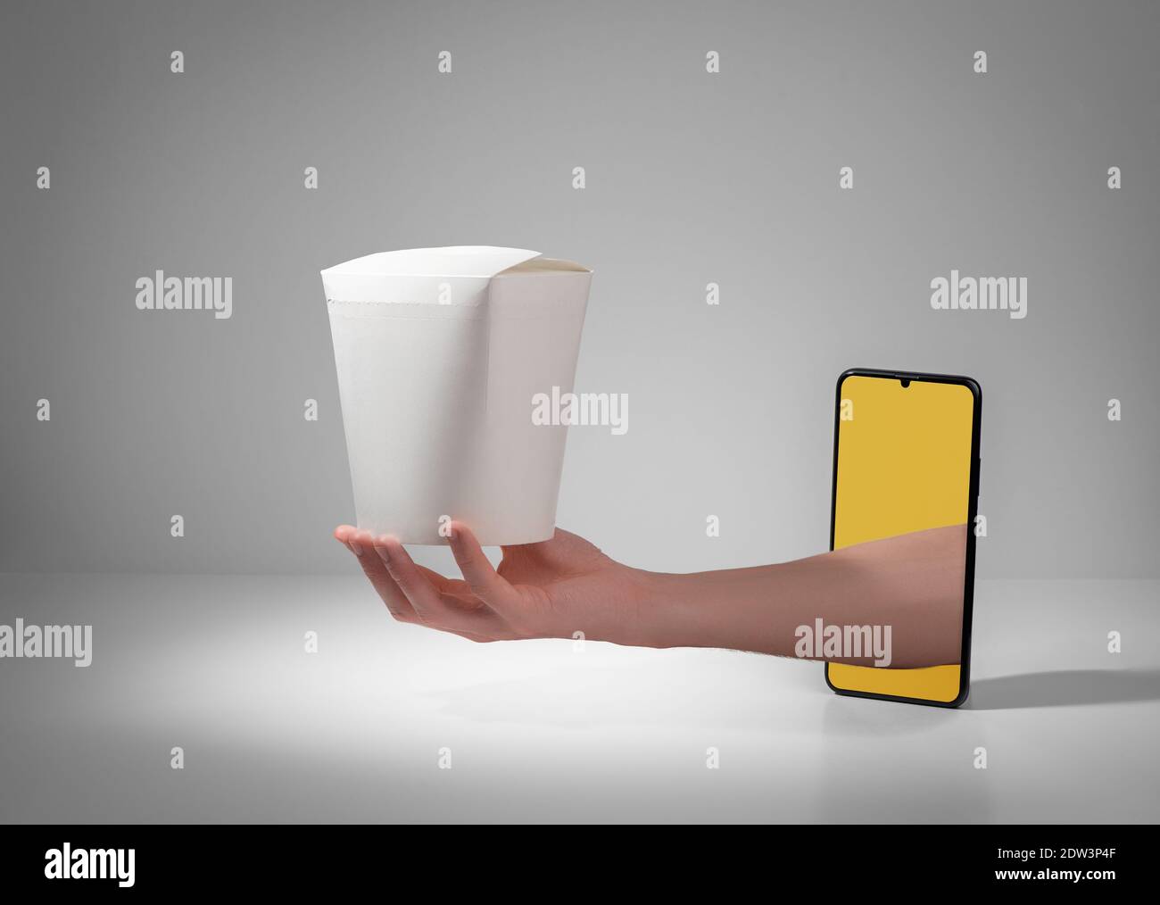 Hand giving a box of wok through a phone screen Stock Photo - Alamy