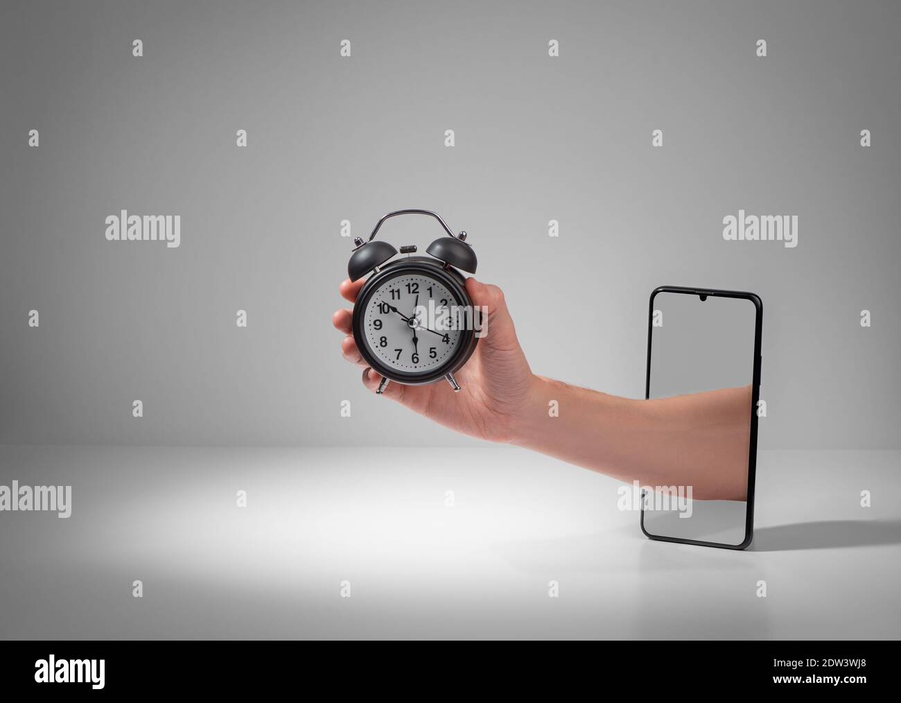 Hand showing a vintage alarm clock through a phone screen Stock Photo ...