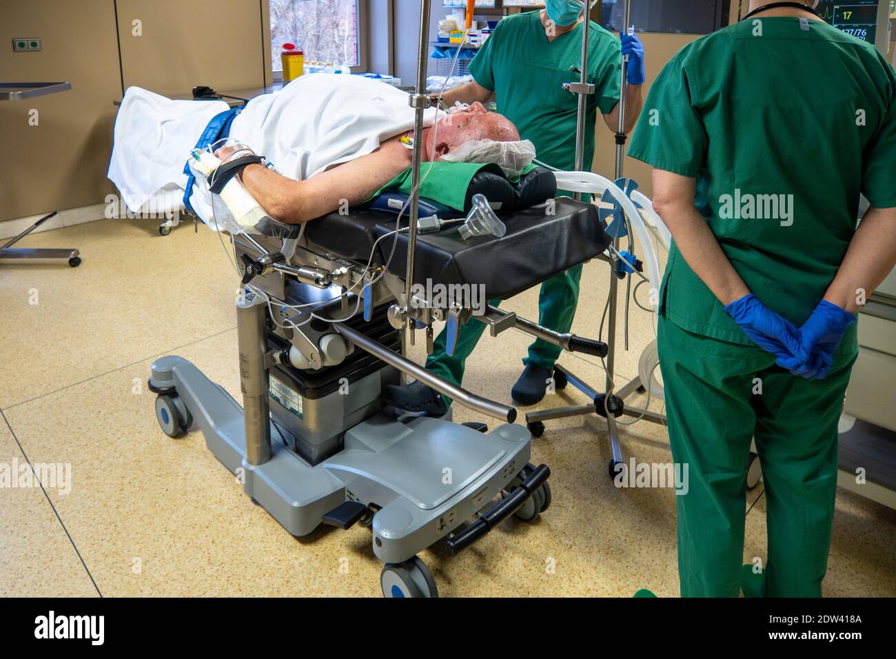 in an operating room, a ventilated patient is monitored by the ...