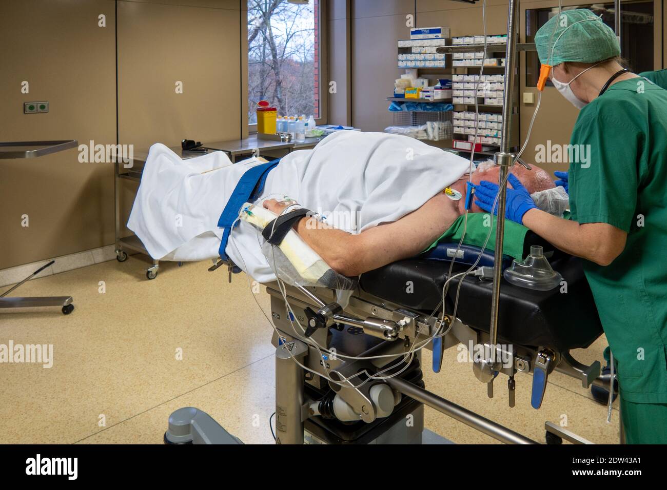 in an operating room, a ventilated patient is monitored by the ...