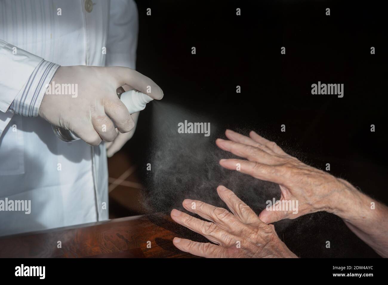The coronavirus. The doctor gives a disinfectant gel on the hands of an ...