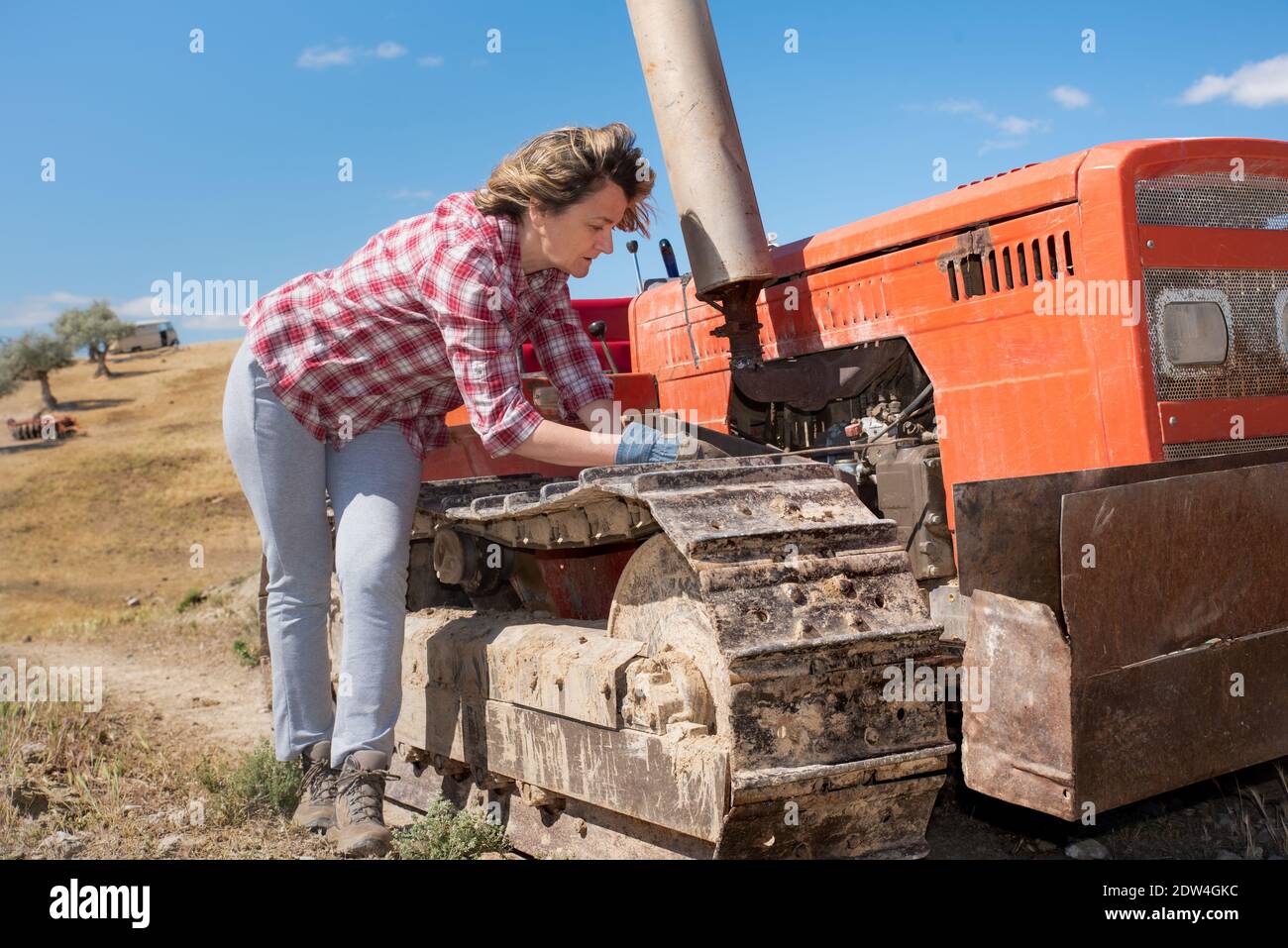 Woman farmer repairing a tractor Stock Photo - Alamy