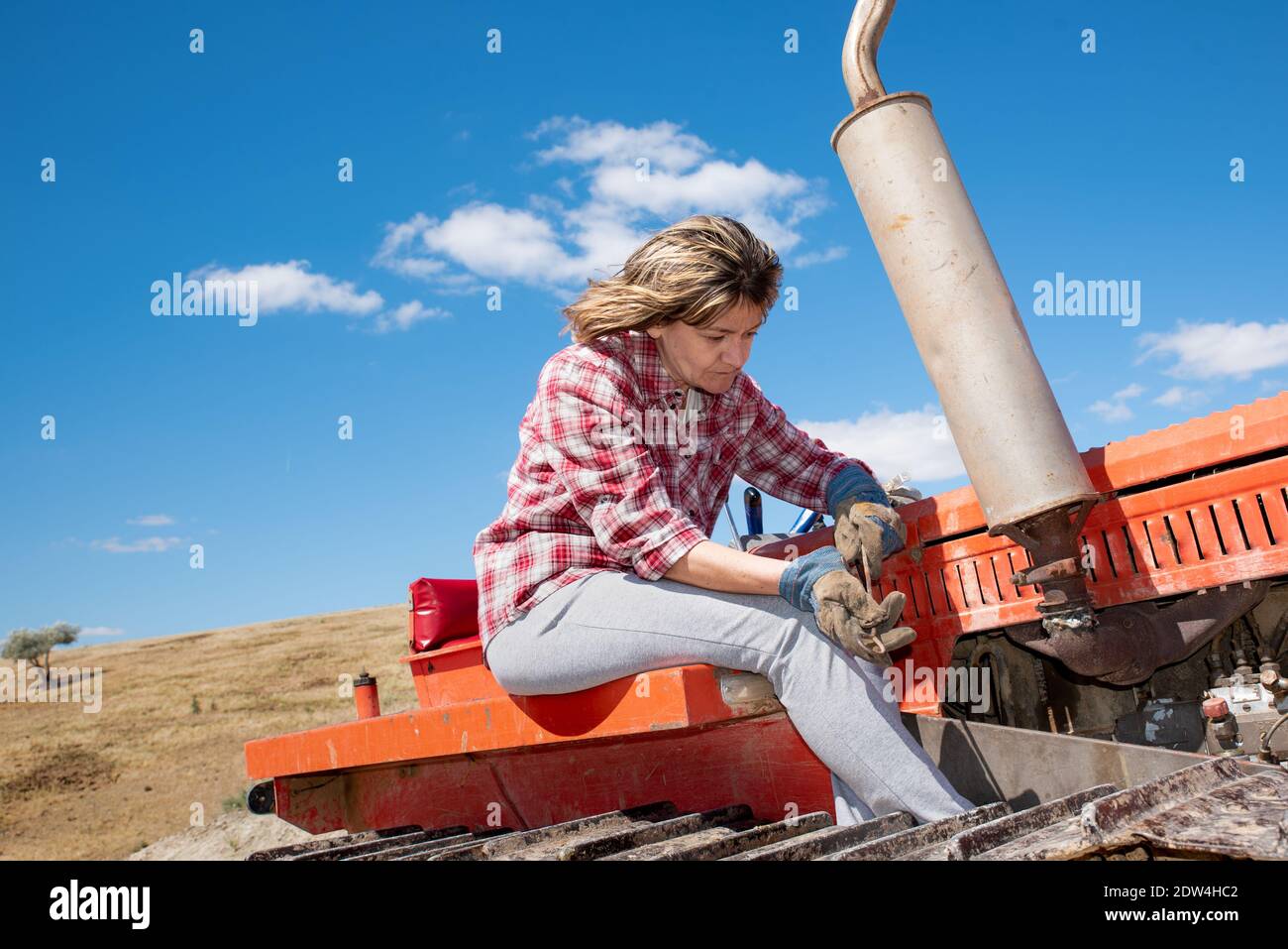 Woman farmer repairing a tractor Stock Photo - Alamy