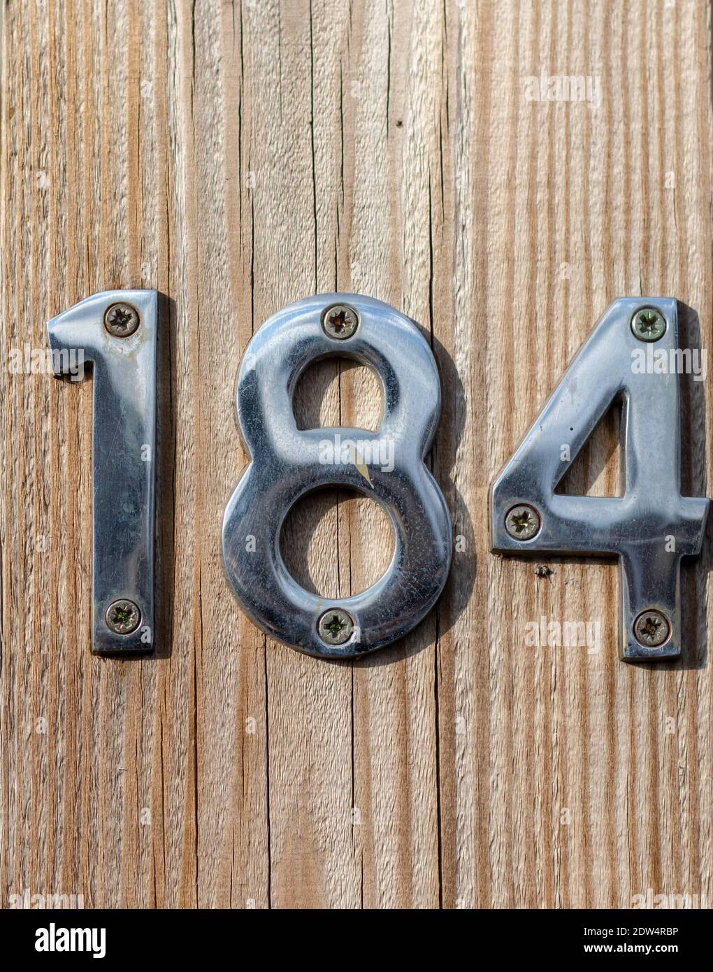 SIlver metal digits on light wood form house number 184 Stock Photo - Alamy