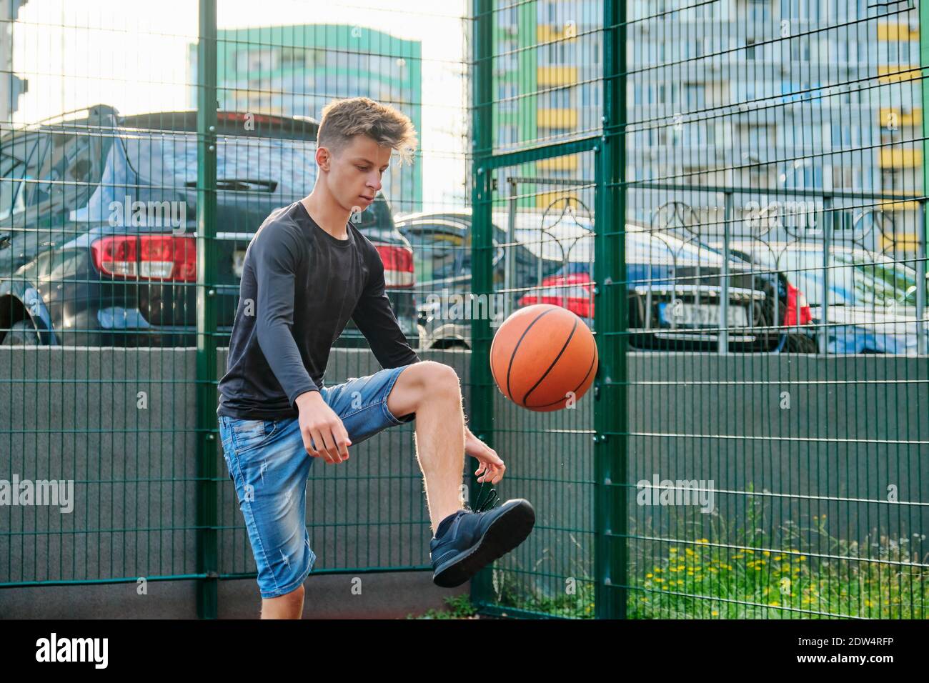 Outdoor portrait of teenage boy playing street basketball Stock Photo ...