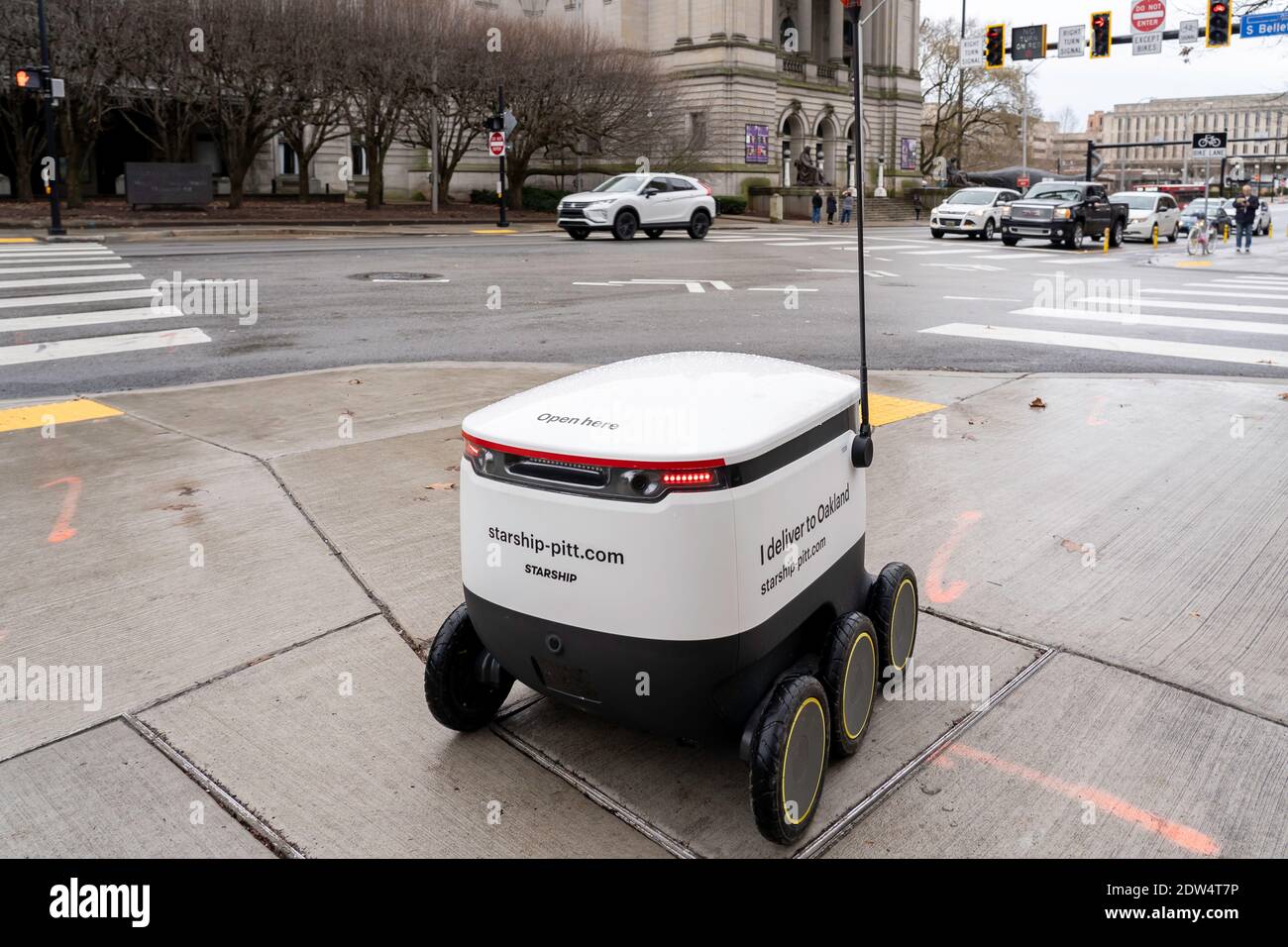 A Starship food delivery robot is driving on the sidewalk in University ...