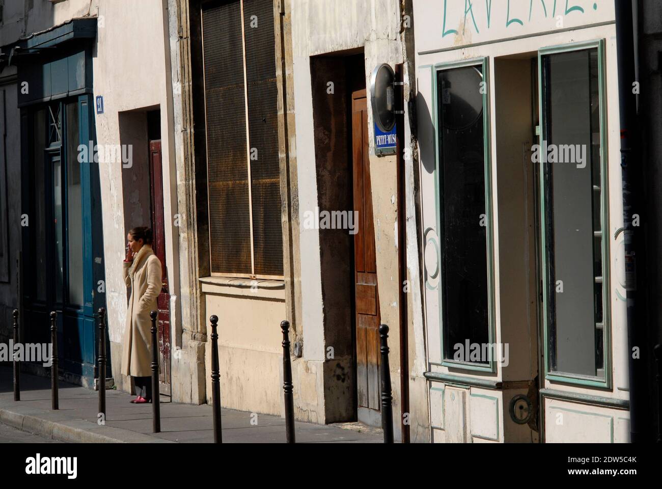 PARIS ELEGANT WOMAN SMOKING ON THE PAVEMENT DURING A WINTER SUNNY DAY ...