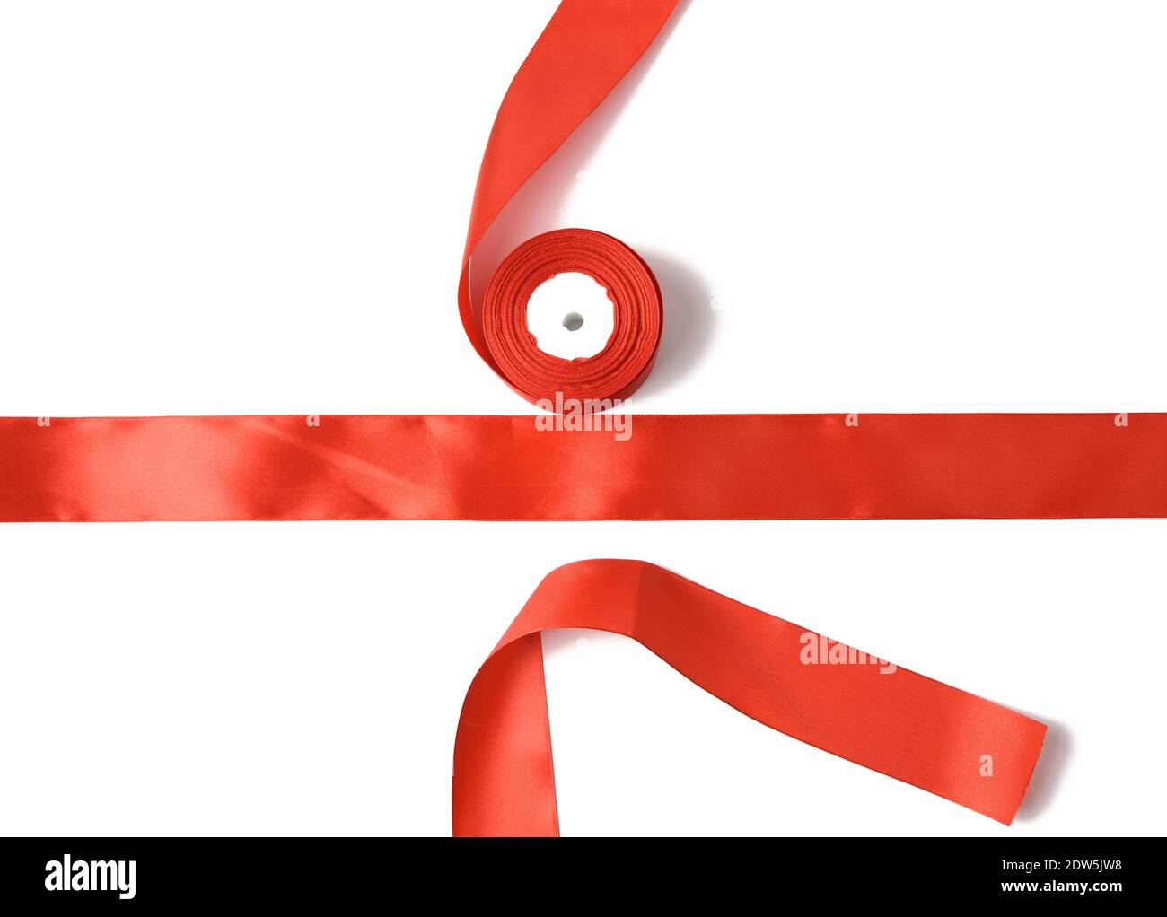 red silk ribbon in a reel on a white background, gift wrapping ...