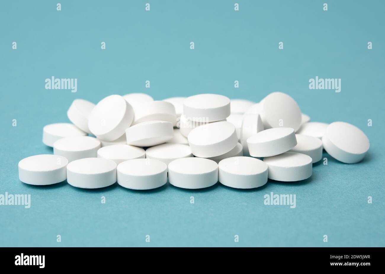 White round pill for healthcare. Medical treatment, bue background ...