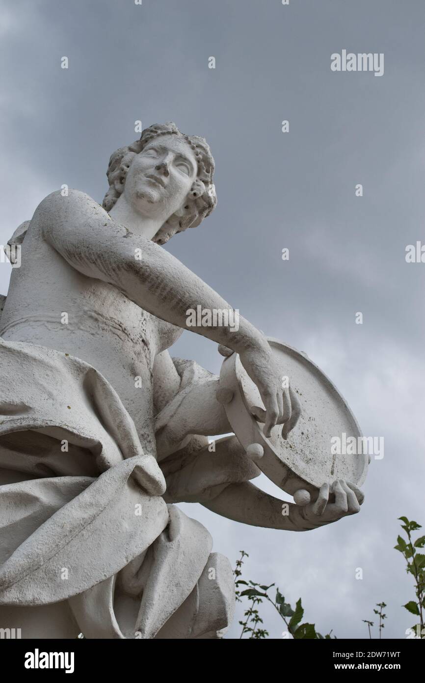 White stone statue of a lady playing a tambourine Stock Photo - Alamy