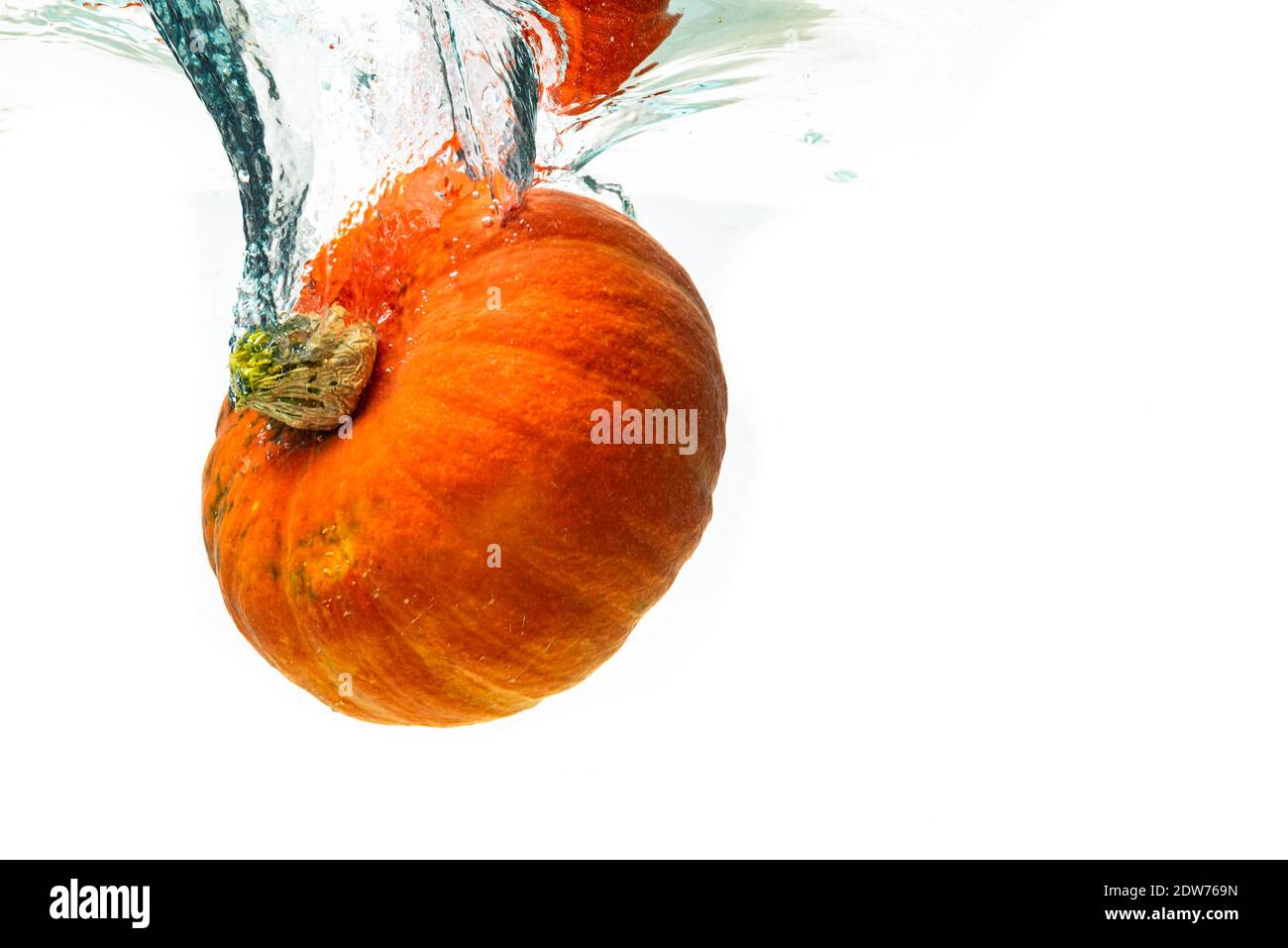 Orange pumpkin splashing into water isolated against white background ...