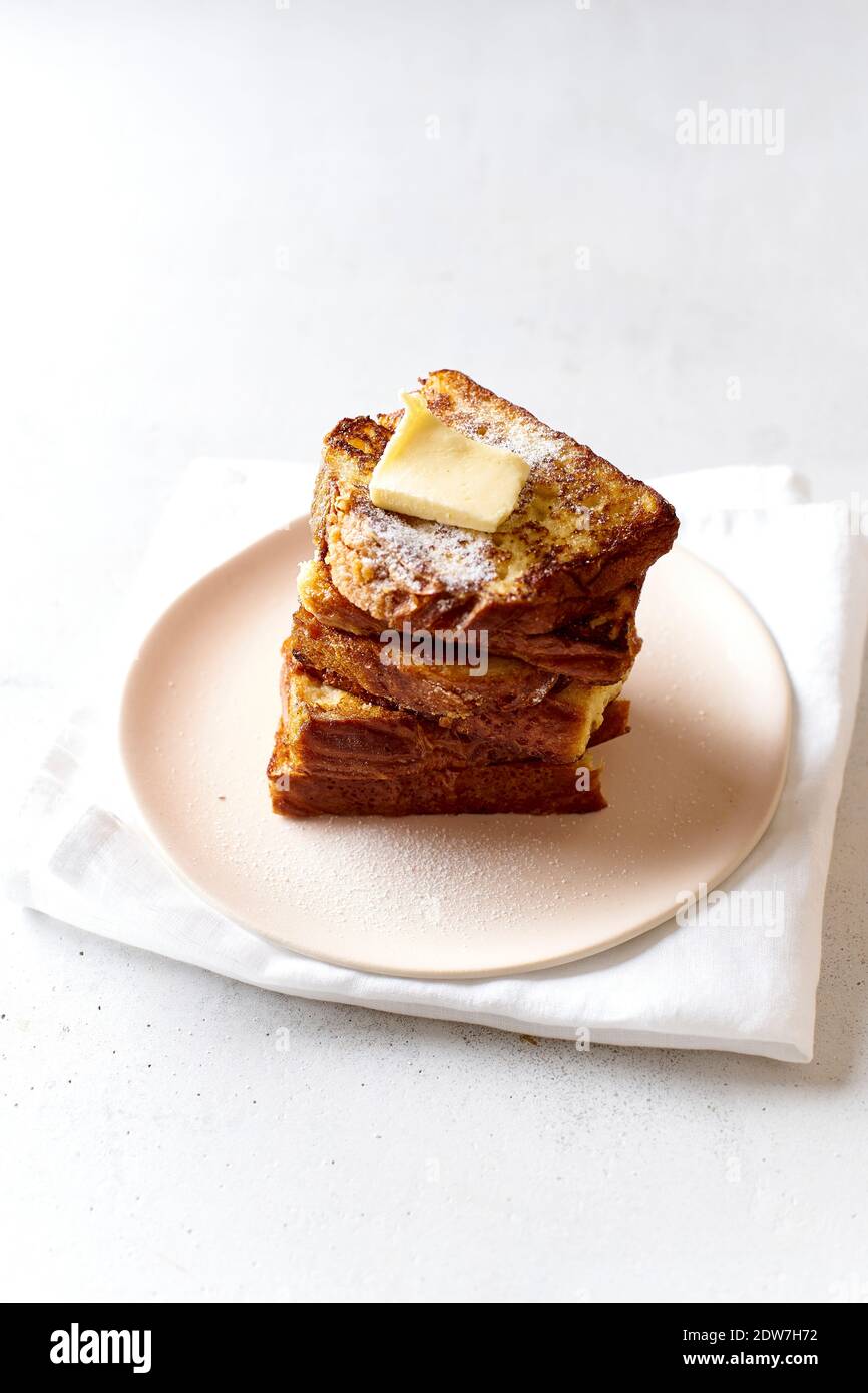 A pile of french toasts for breakfast with butter and powdered sugar ...