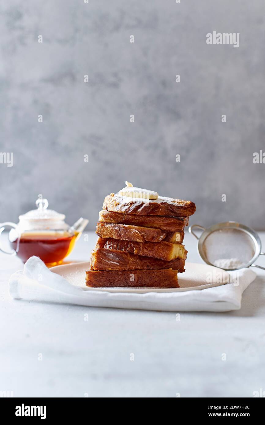 A pile of french toasts for breakfast with butter and powdered sugar ...