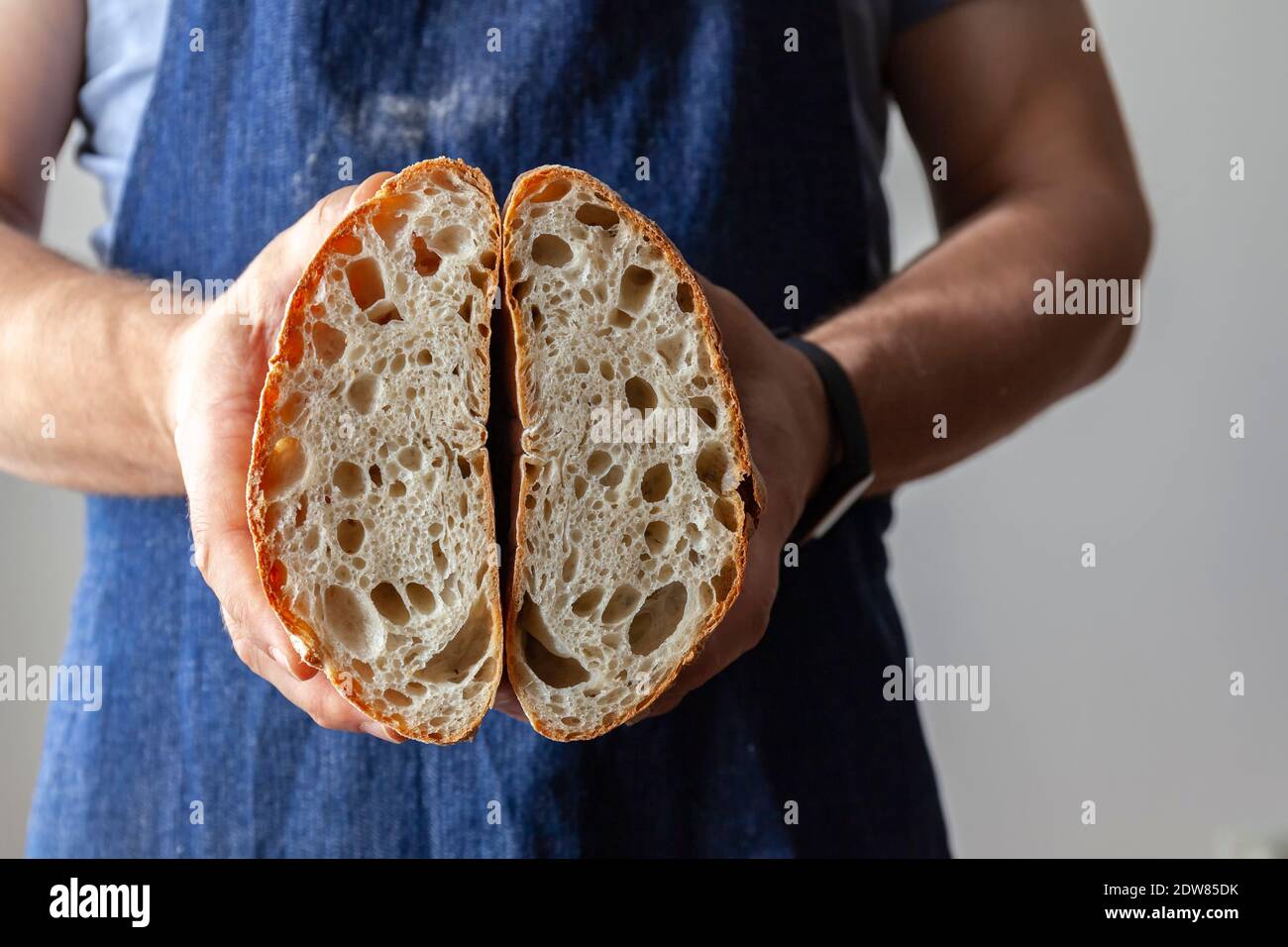 Baker dressed in an apron holds an Italian classic Ciabatta bread Stock ...