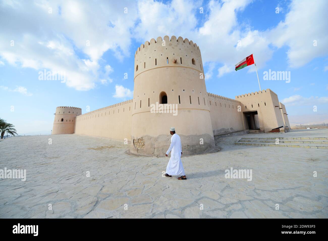 Omani men walking by the Sunaysilah Fort in Sur, Oman Stock Photo - Alamy