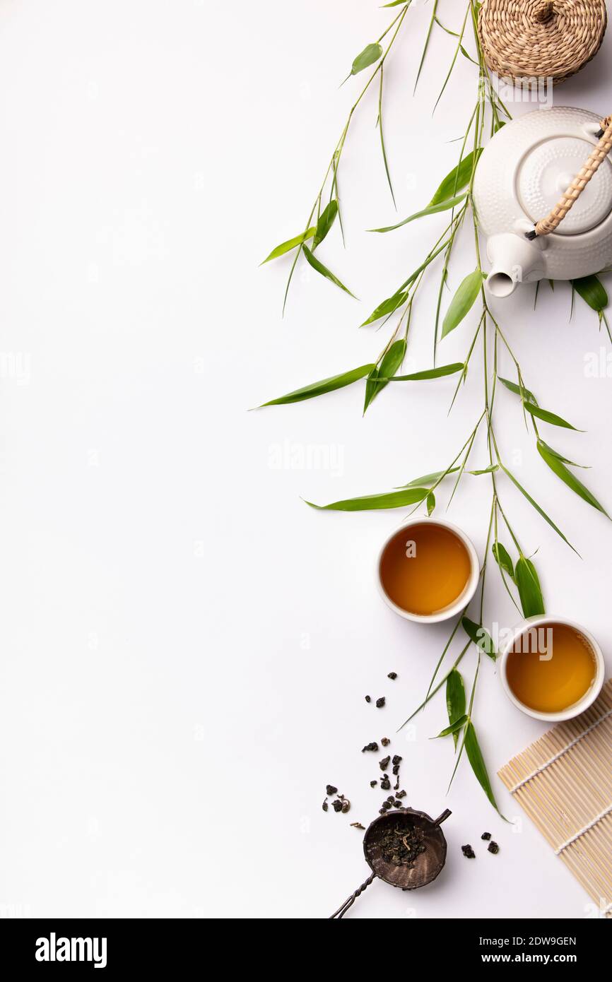 Asian food background set with green tea, cups and teapot with bamboo ...