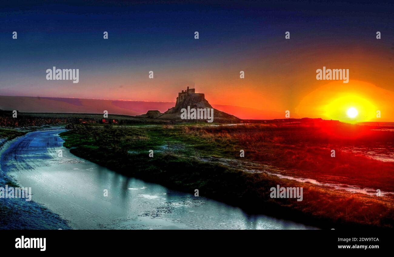 Winter red dawn breaks over an icy path at Lindisfarne castle on Holy ...
