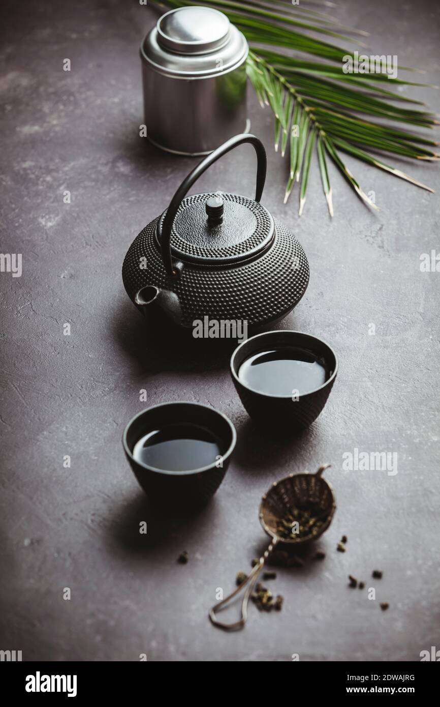 Traditional Asian tea ceremony arrangement. Iron teapot, cups, dried ...