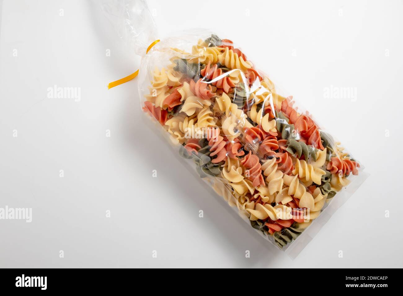 Fusilli type tricolor pasta package closed on a white surface. Concept ...