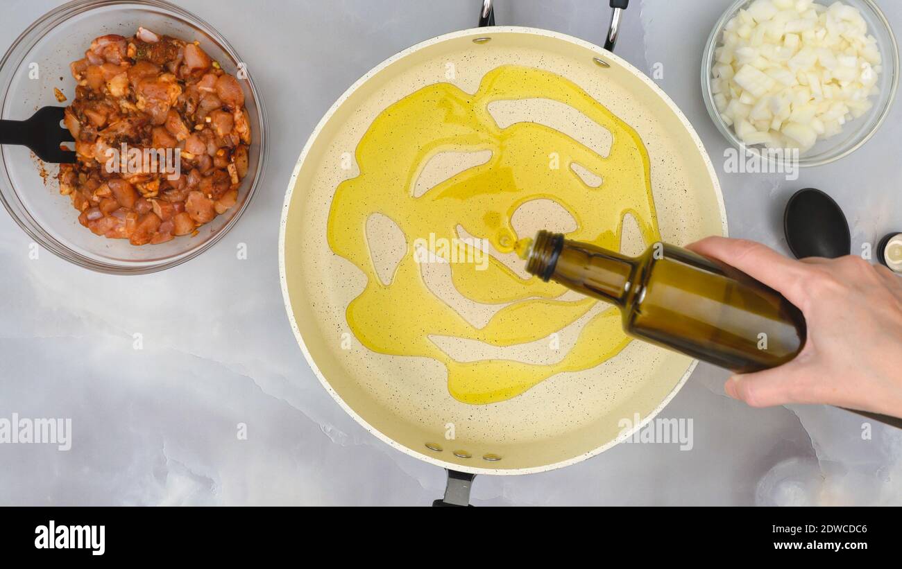 Chef pouring olive oil on frying pan, close up view from above. Cooking ...