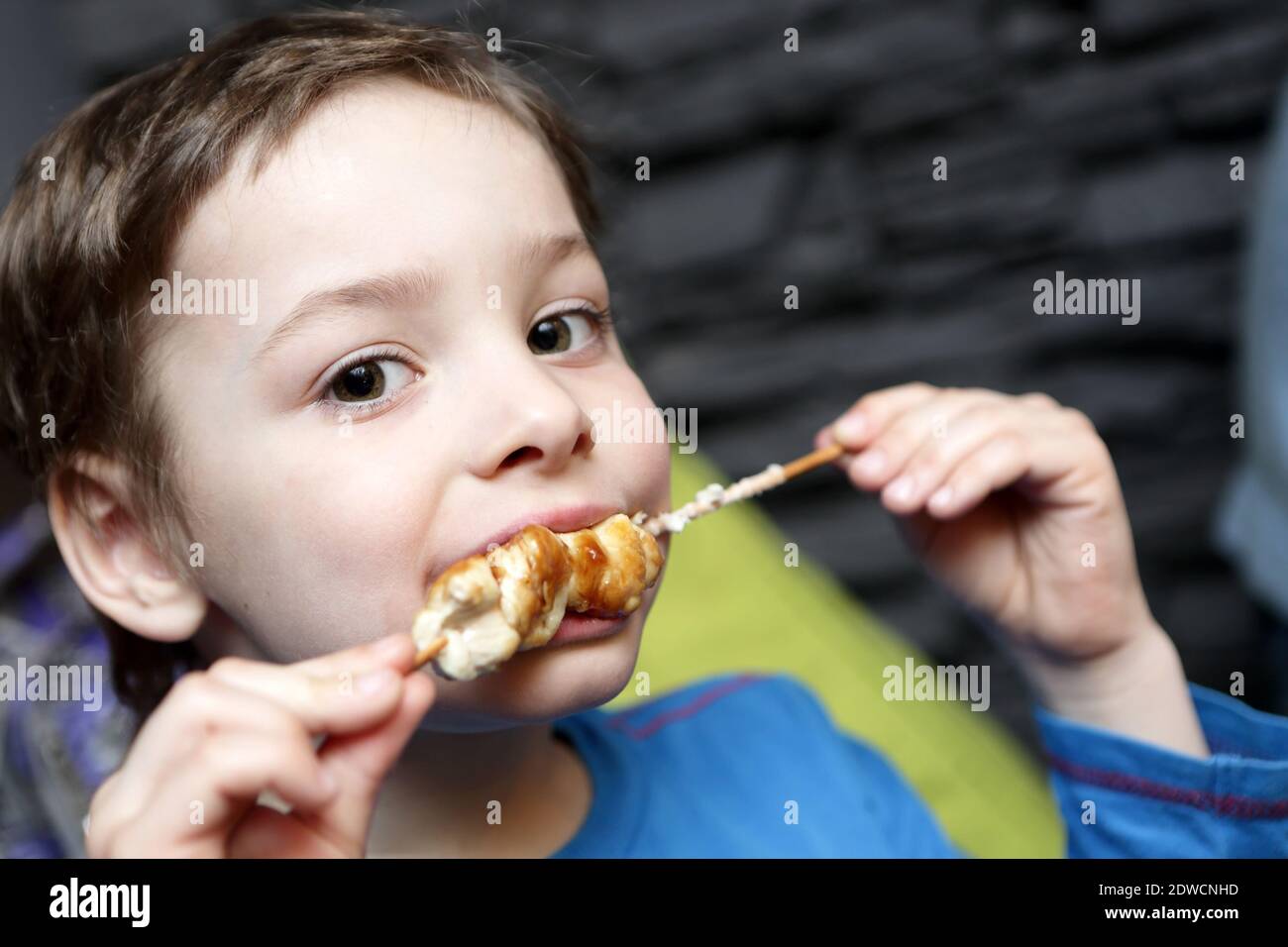 Child eating chicken kebab in a restaurant Stock Photo - Alamy