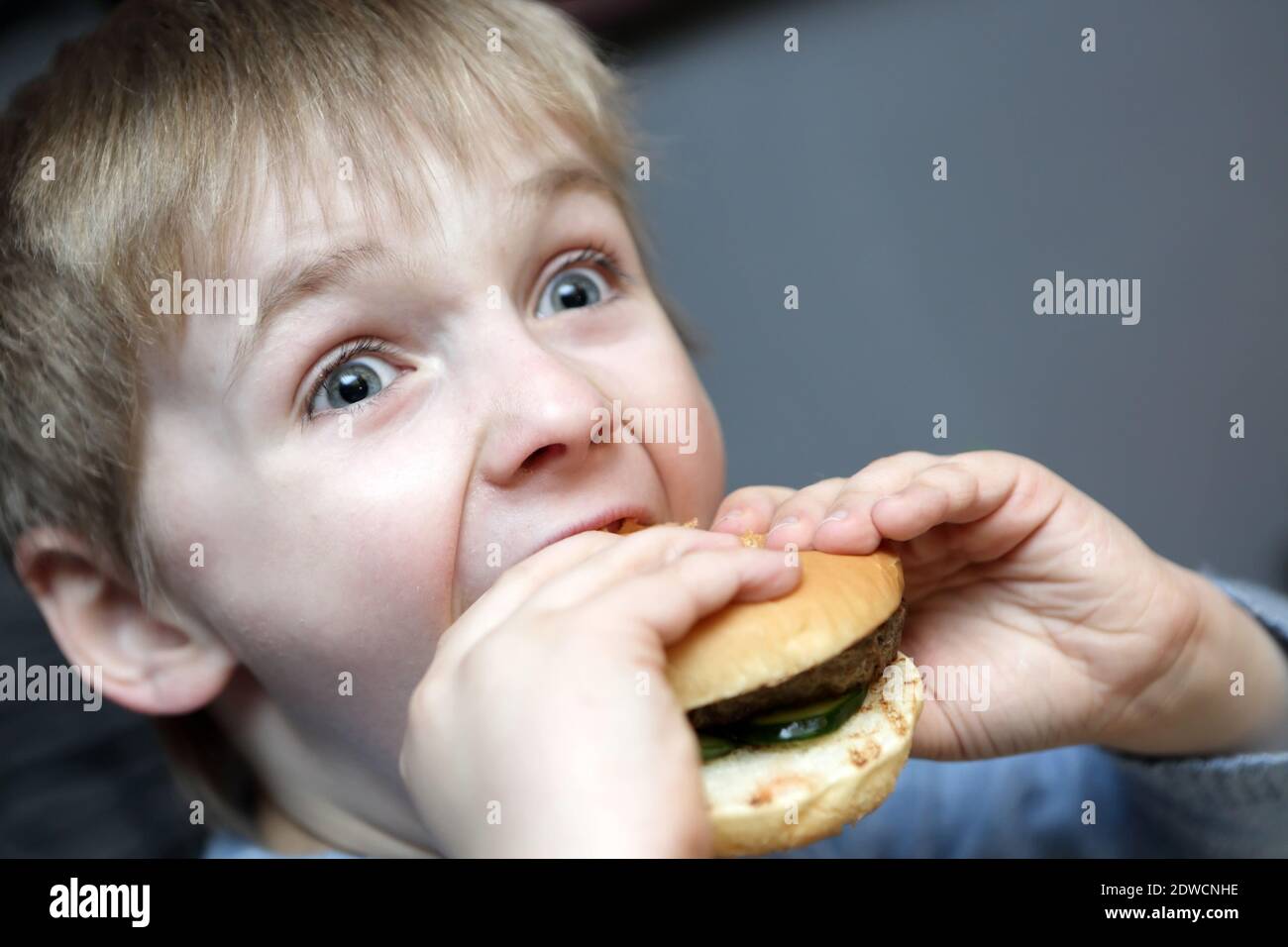 Boy biting into burger hi-res stock photography and images - Alamy