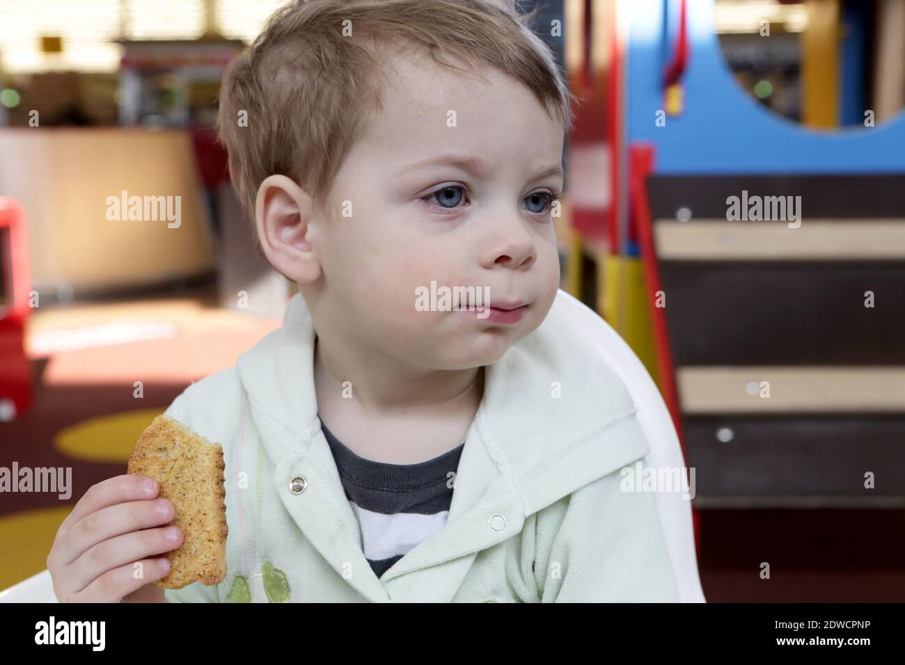 Kid is eating biscuit in a cafe Stock Photo - Alamy