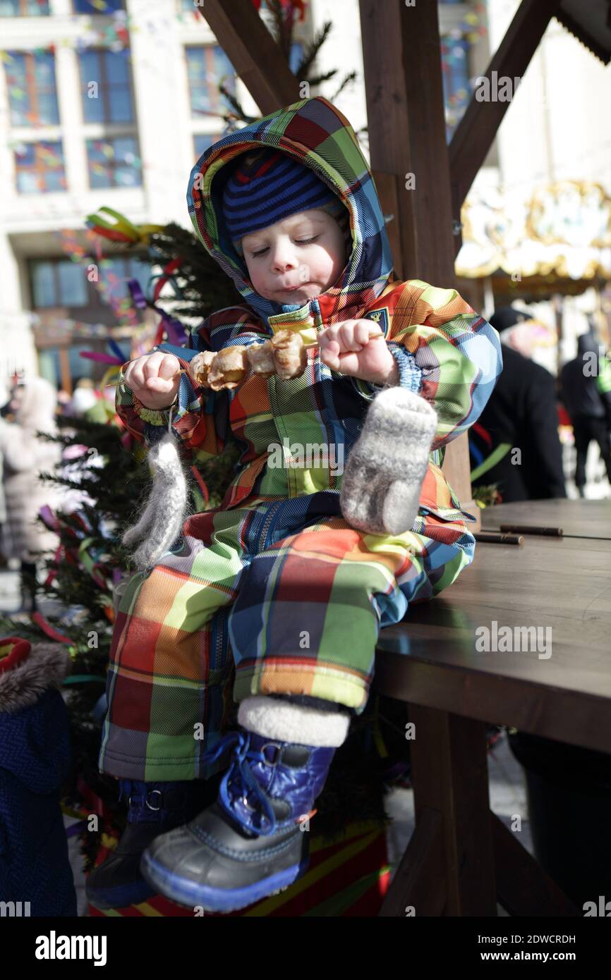 Child eating grilled potato on the street Stock Photo - Alamy