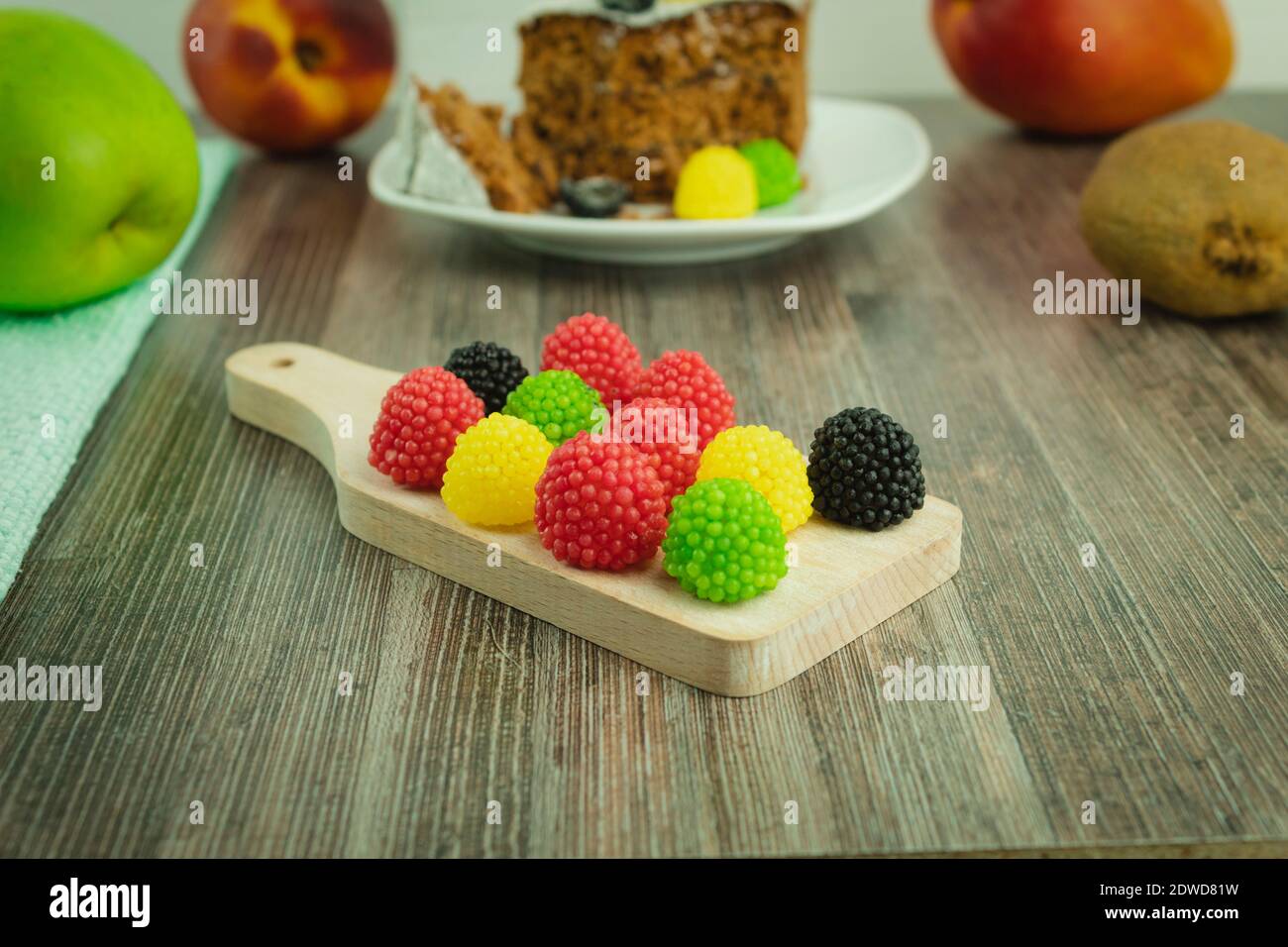 Multi-colored jelly candies and cake. Bitten cake. The process of ...