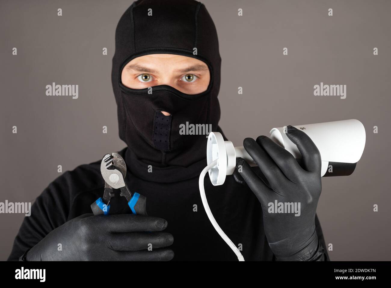 Picture of thief wearing black face mask is trying to turn off a ...