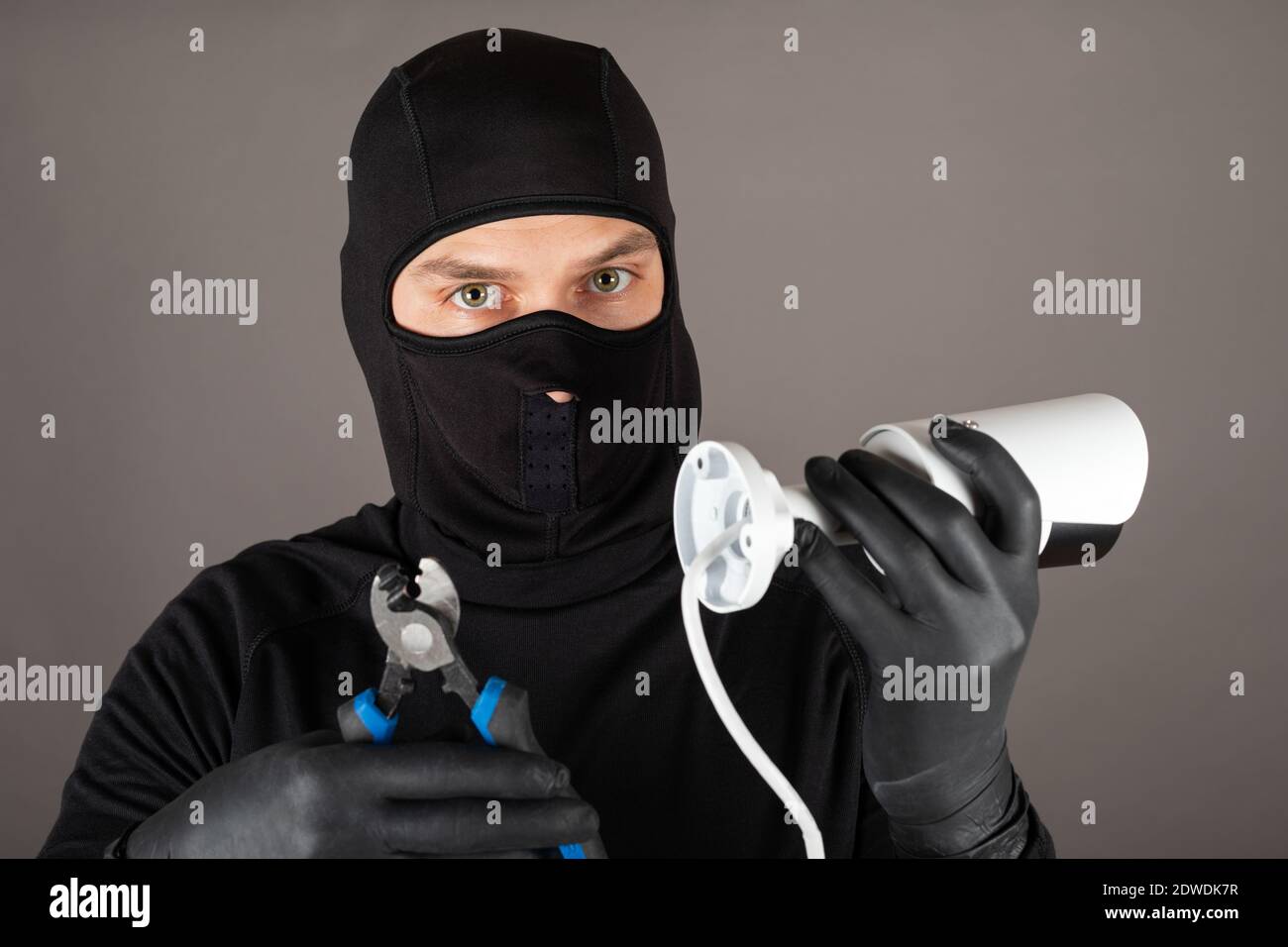 Picture of thief wearing black face mask is trying to turn off a ...