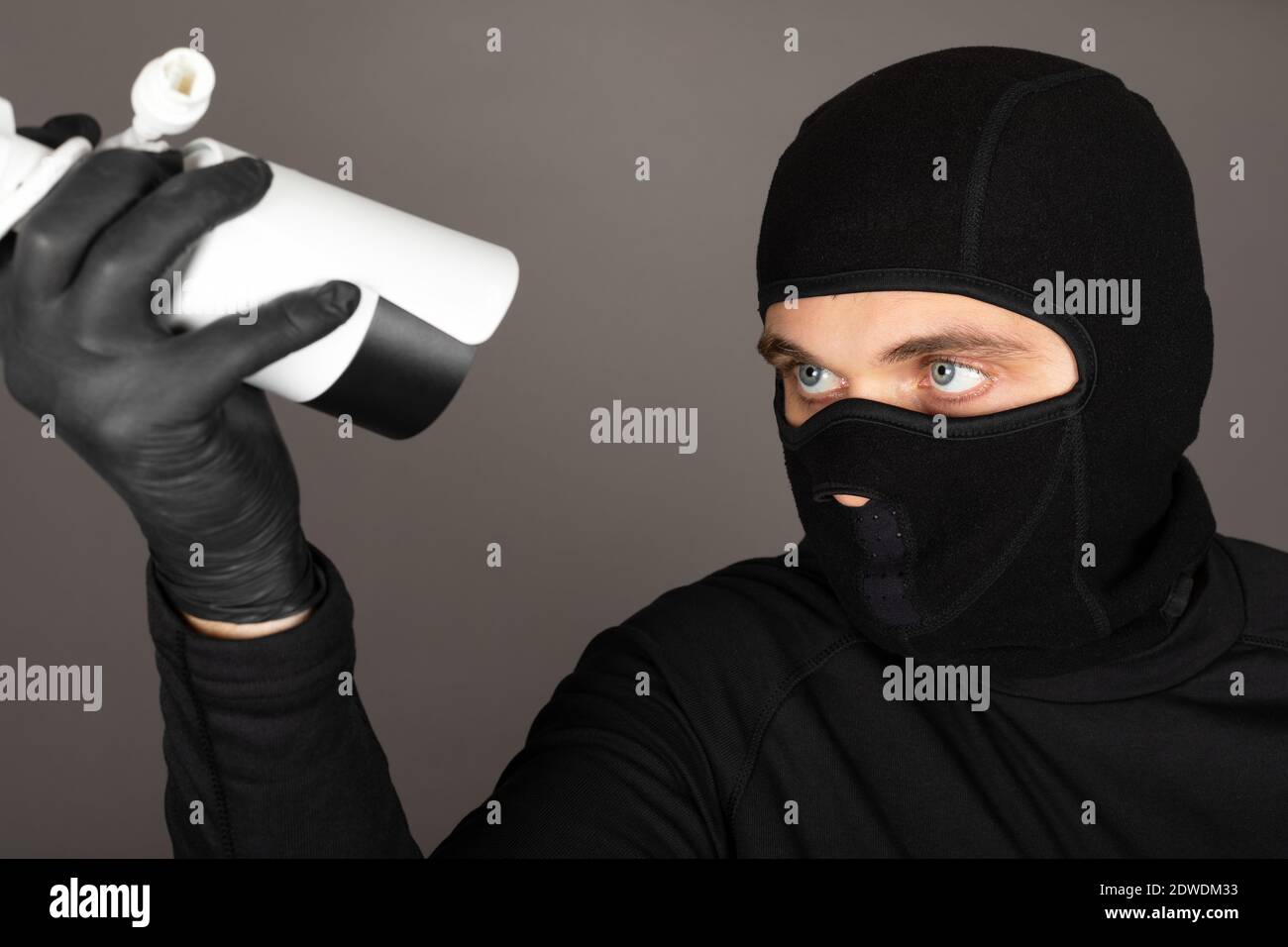 Picture of thief wearing black face mask is trying to turn off a ...
