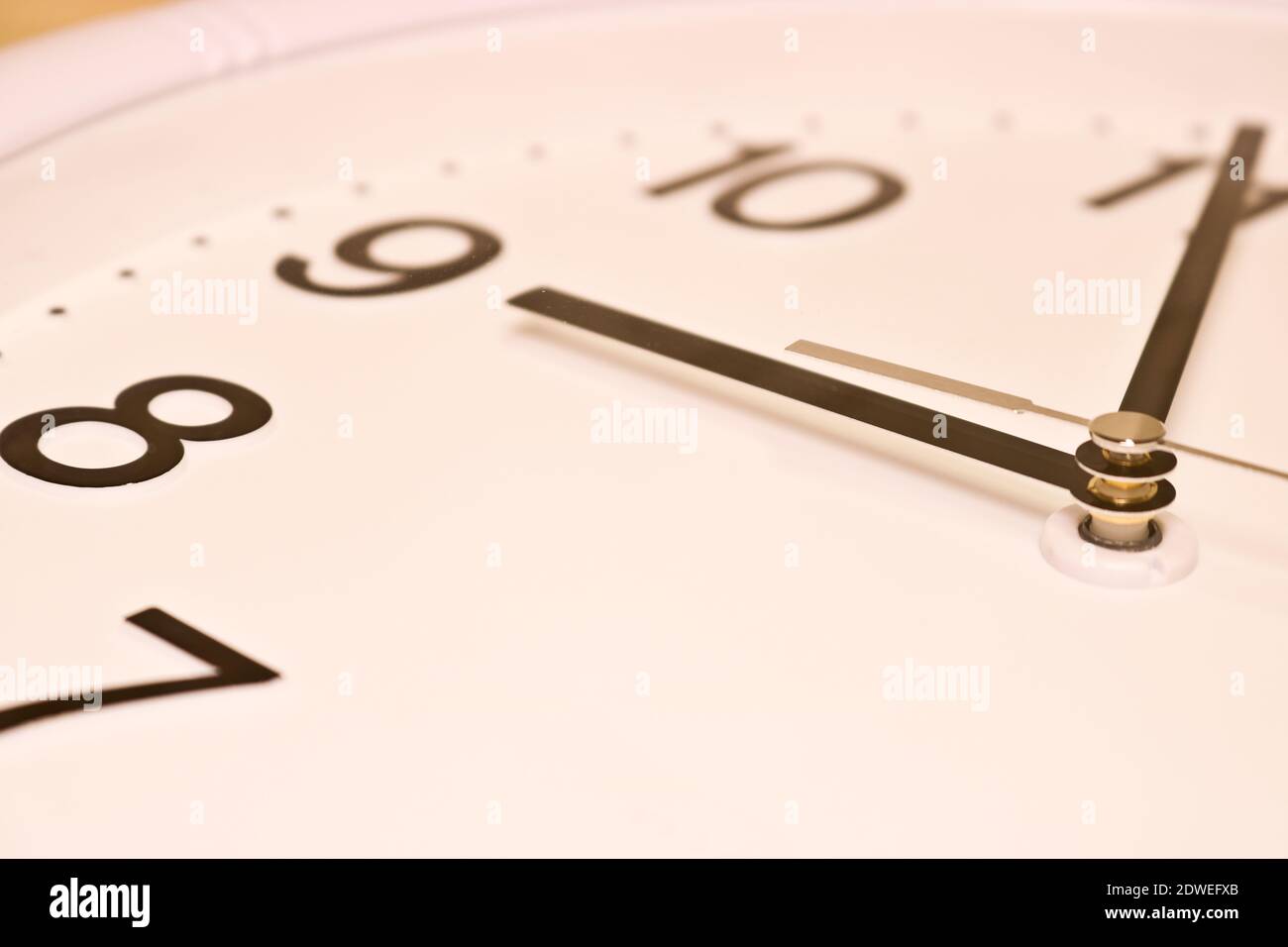 Dial of an analog clock close up. Time 08:55. White dial, black ...
