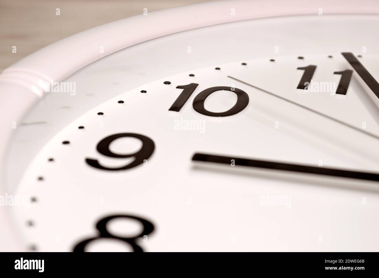 Dial of an analog clock close up. Time 08:55. White dial, black ...