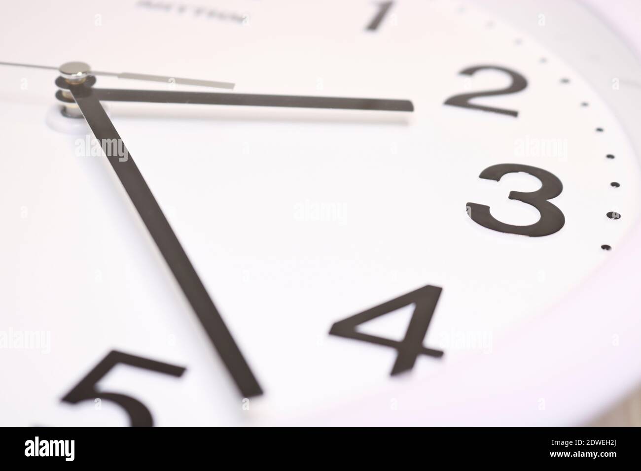 Dial of an analog clock close up. The time is 14:23. White dial, black ...