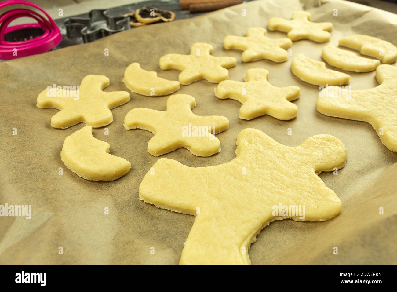 The Christmas gingerbread cookies are laid out on a baking sheet and ...