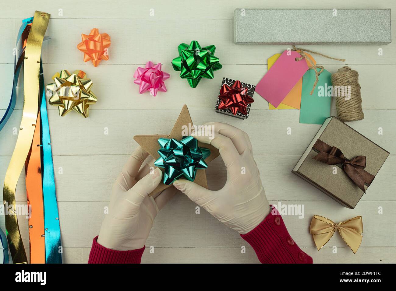 Women's hands in protective gloves are packing gifts for the holidays ...